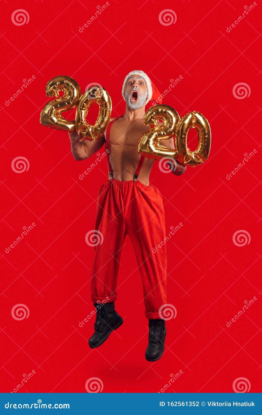 Christmas Freestyle Young Santa Claus Bare Muscular Upper Body In Hat Standing Isolated On Red