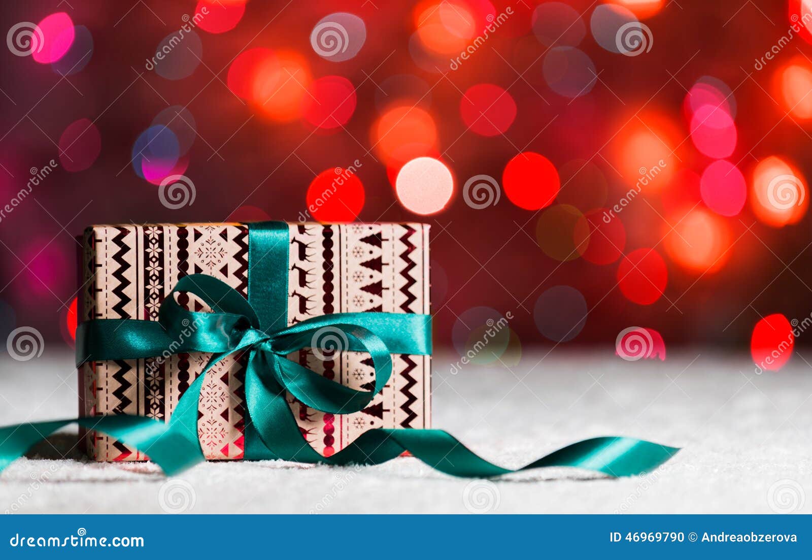 Christmas Present with Green Bow in Snow with Bokeh in the Background ...