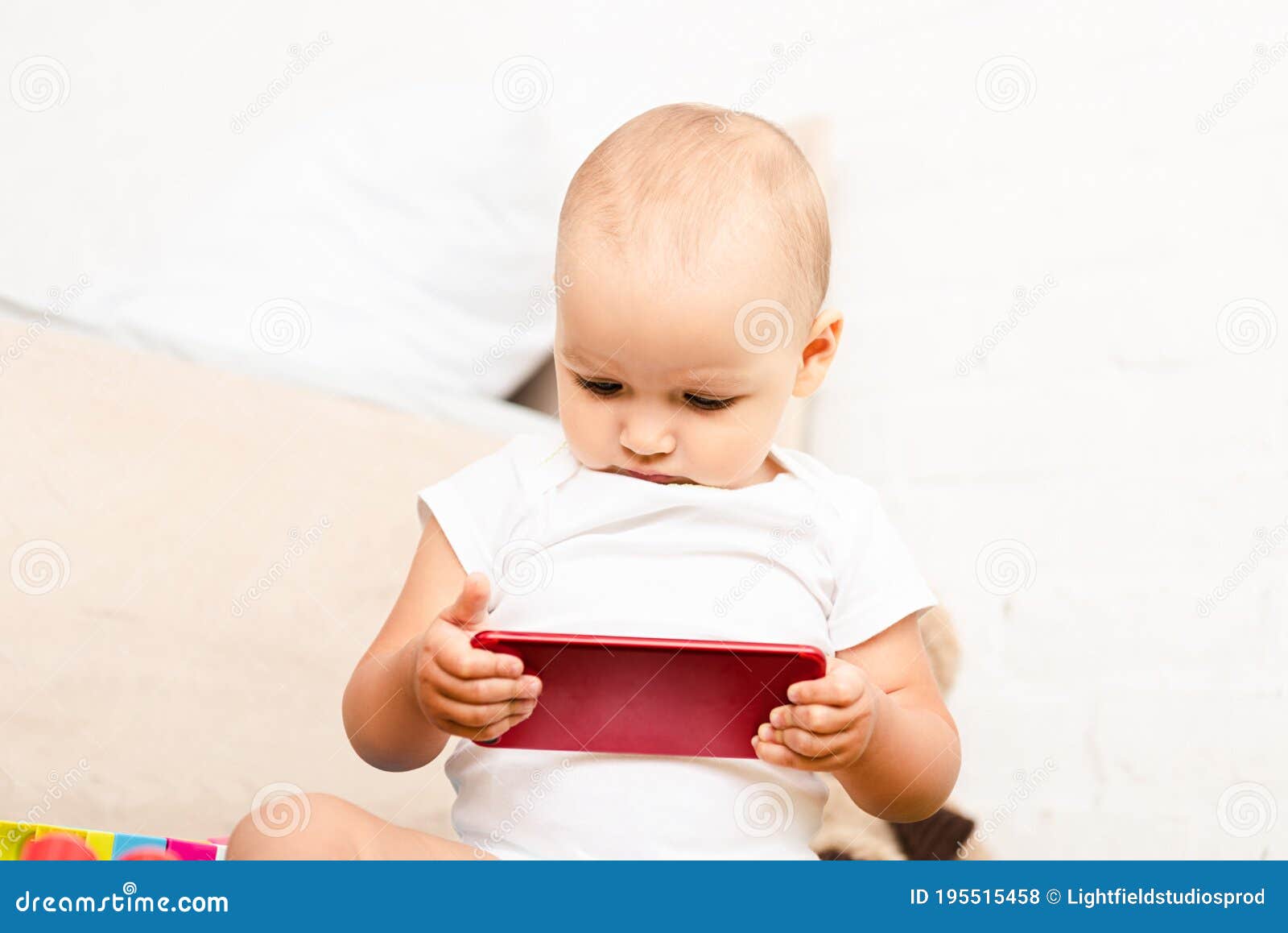 Chubby Kid Looking at Red Smartphone in White Room Stock Photo - Image ...