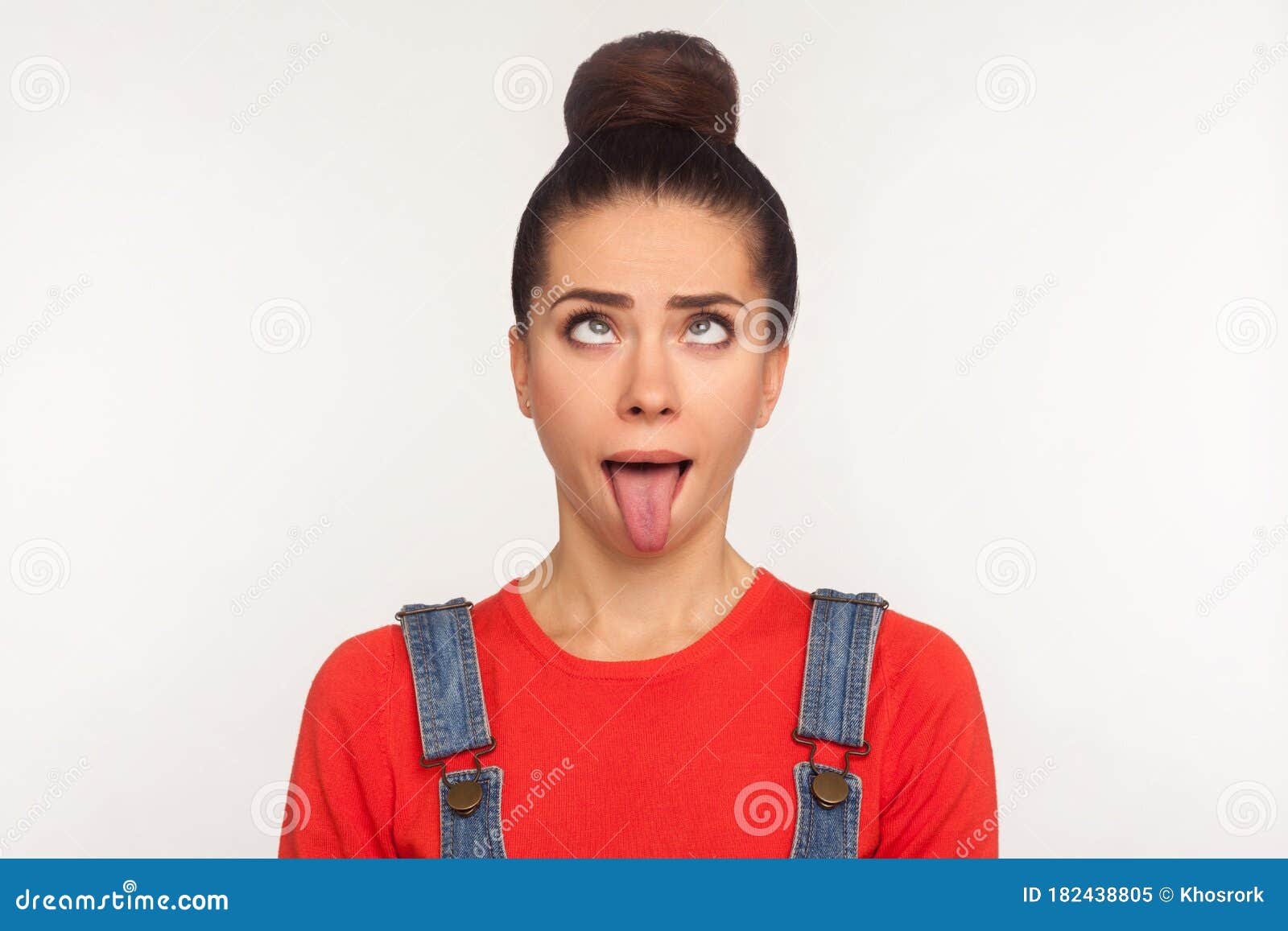 Cierre De Una Divertida Chica Con Un Bollo De Pelo Mirando Hacia Arriba