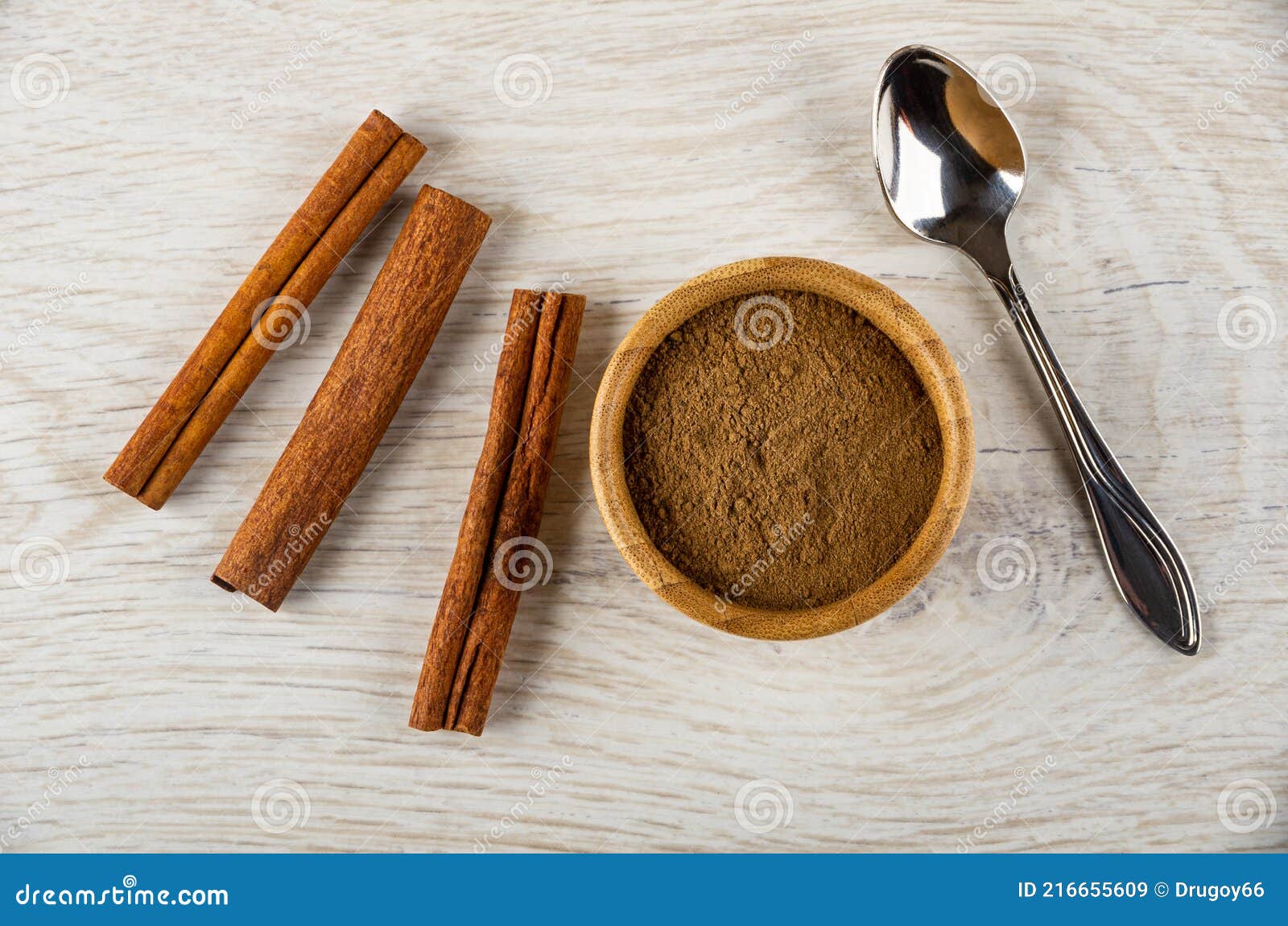 Cinnamon Sticks and Bowl with Ground Cinnamon, Spoon on Wooden Table ...