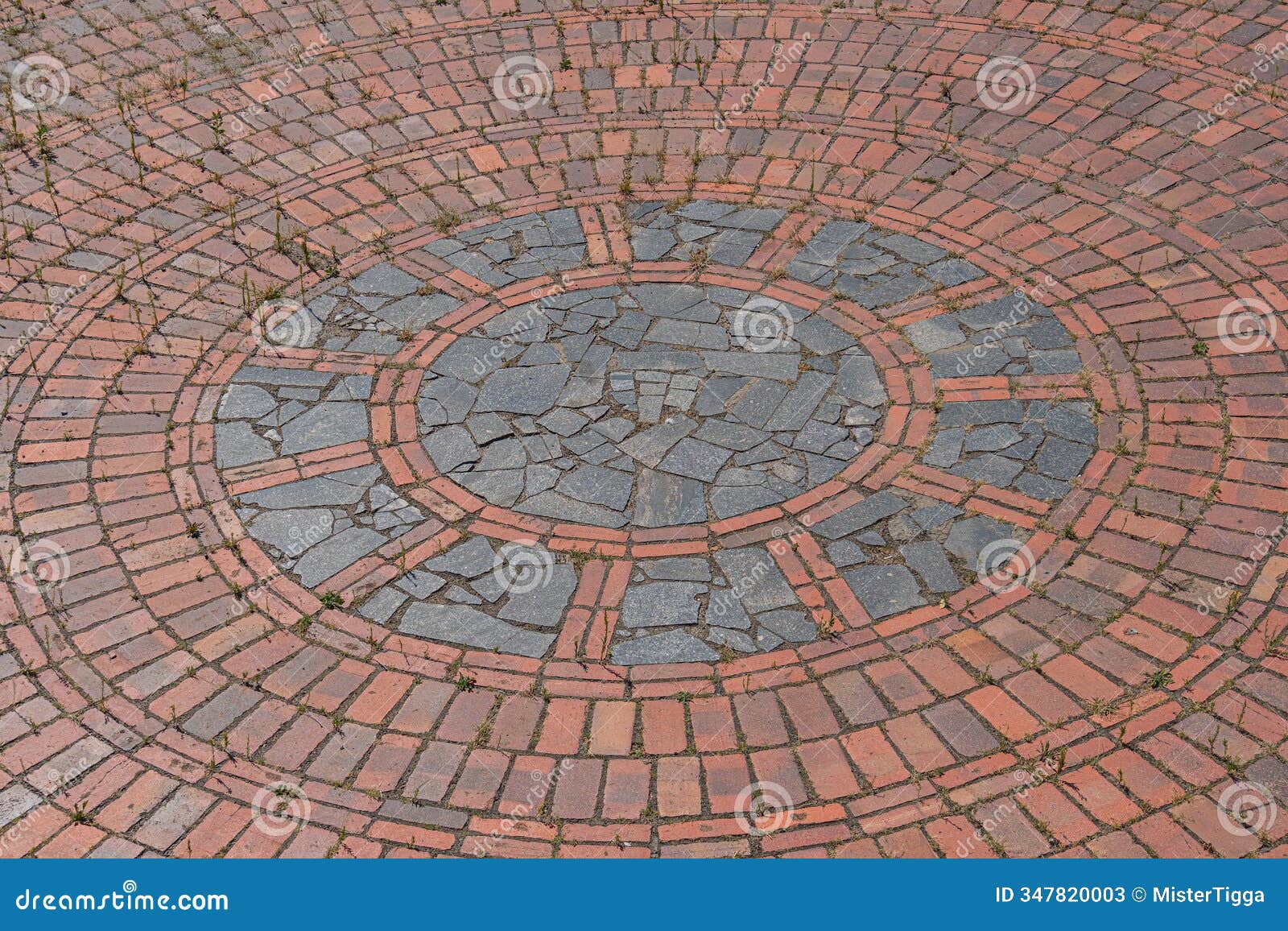 Circular Stone Pattern on a Red Brick Surface, Resembling a Worn ...