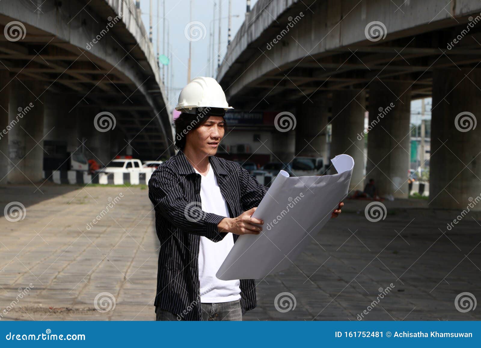 Civil Engineer Man with Helmet, Standing and Looks at the Project ...