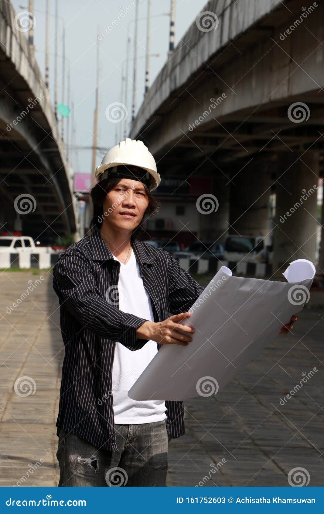 Civil Engineer Man with Helmet, Standing and Looks at the Project ...