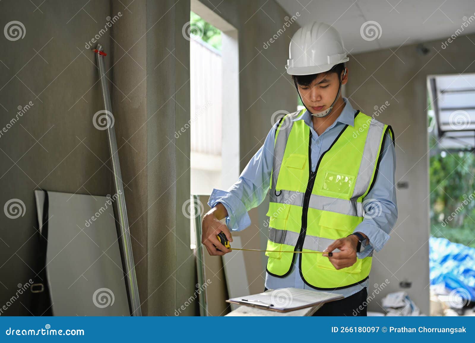 Civil Engineer Wearing Hardhat Examining Plans at Construction Site ...