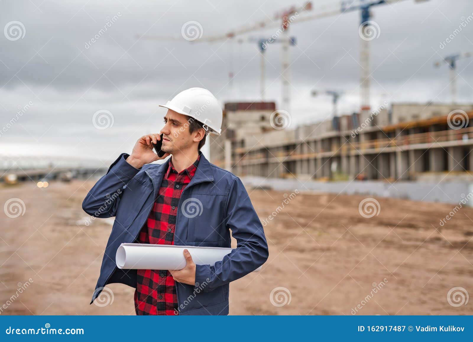 Civil Engineer in a White Helmet with Documents in His Hands Talking on ...