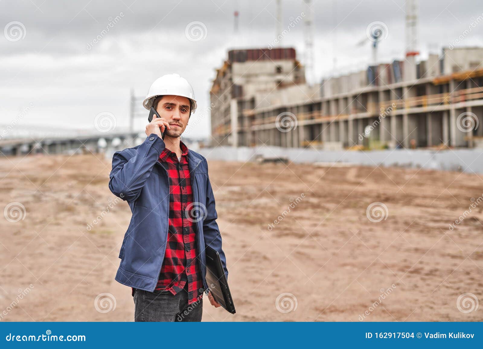 Civil Engineer in a White Helmet with Documents in His Hands Talking on ...