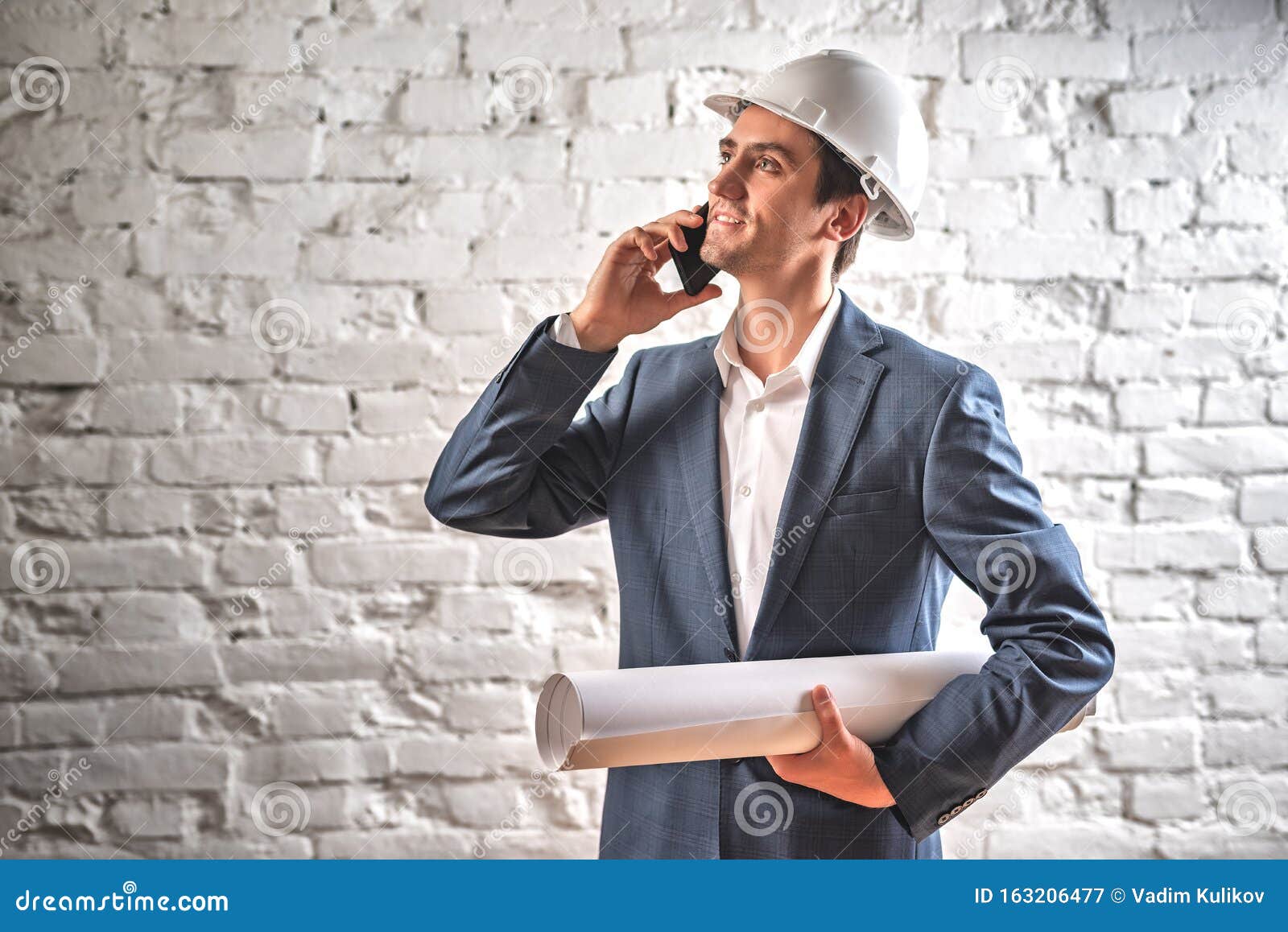 Civil Engineer in a White Helmet with Documents in His Hands Talking on ...