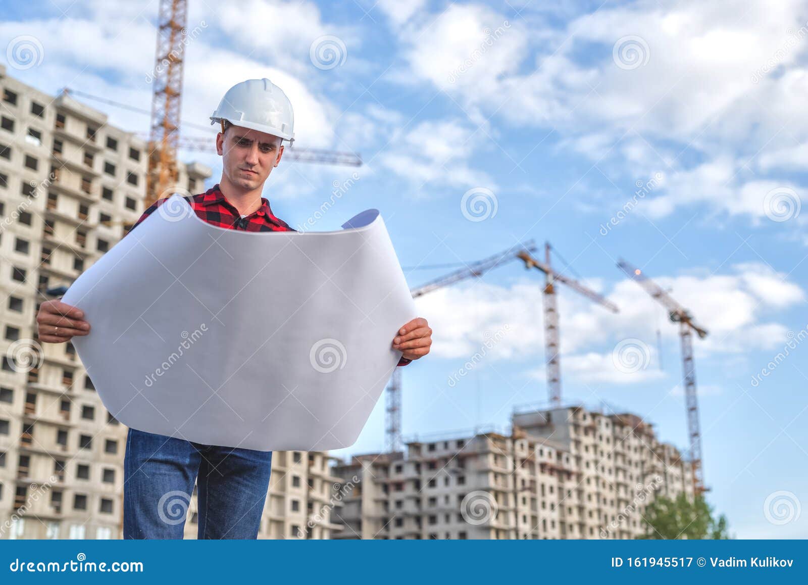 Civil Engineer in a White Helmet Looking Documents on the Background of ...