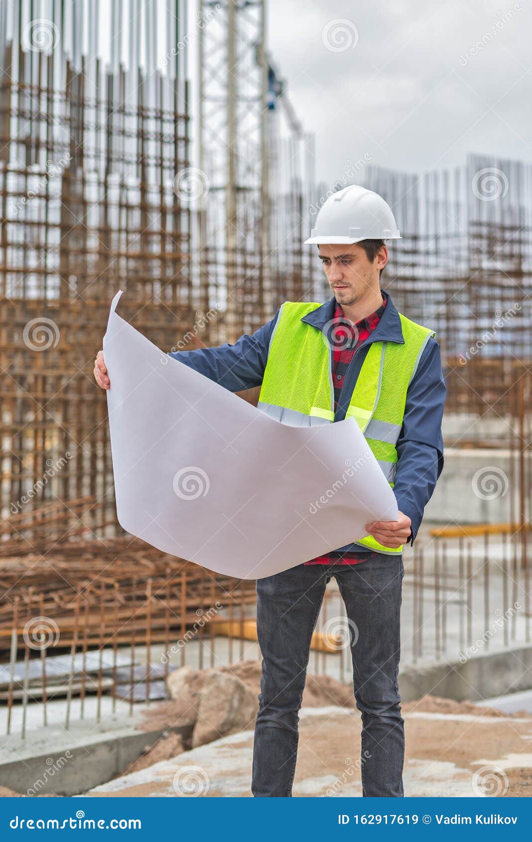 Civil Engineer in a White Helmet Looking Documents on the Background of ...
