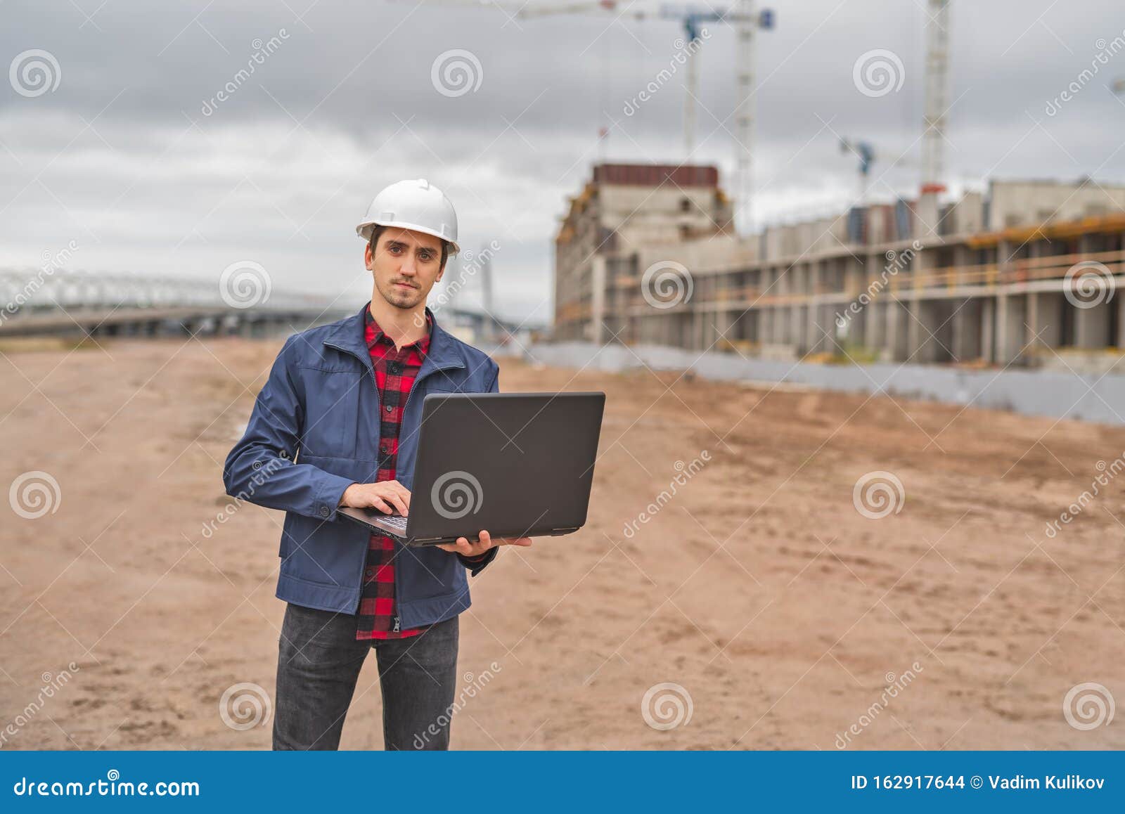 Civil Engineer in a White Helmet Looking Documents on the Background of ...