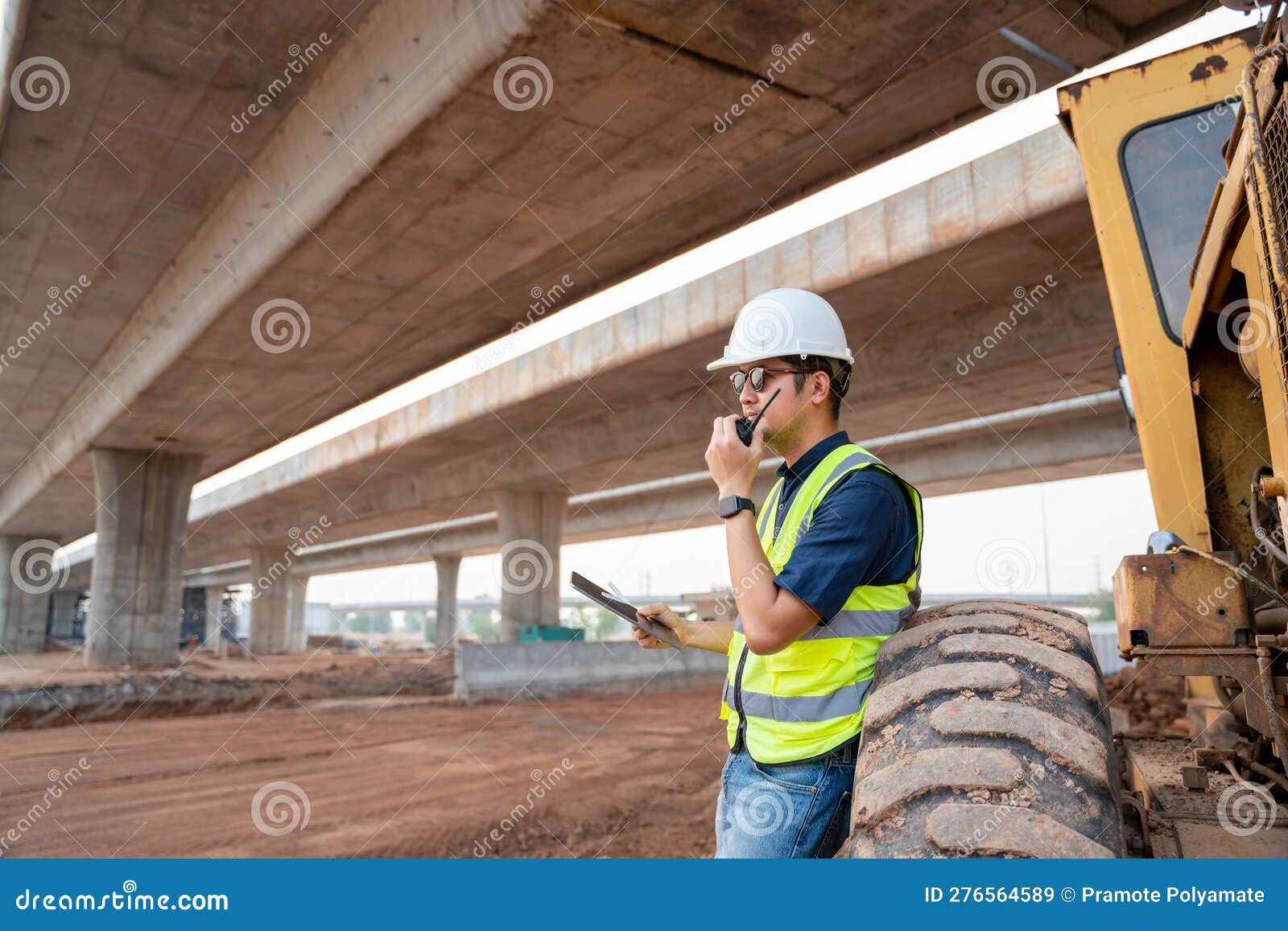 A Civil Engineer Working beside the Wheels of Grader Industrial Machine ...