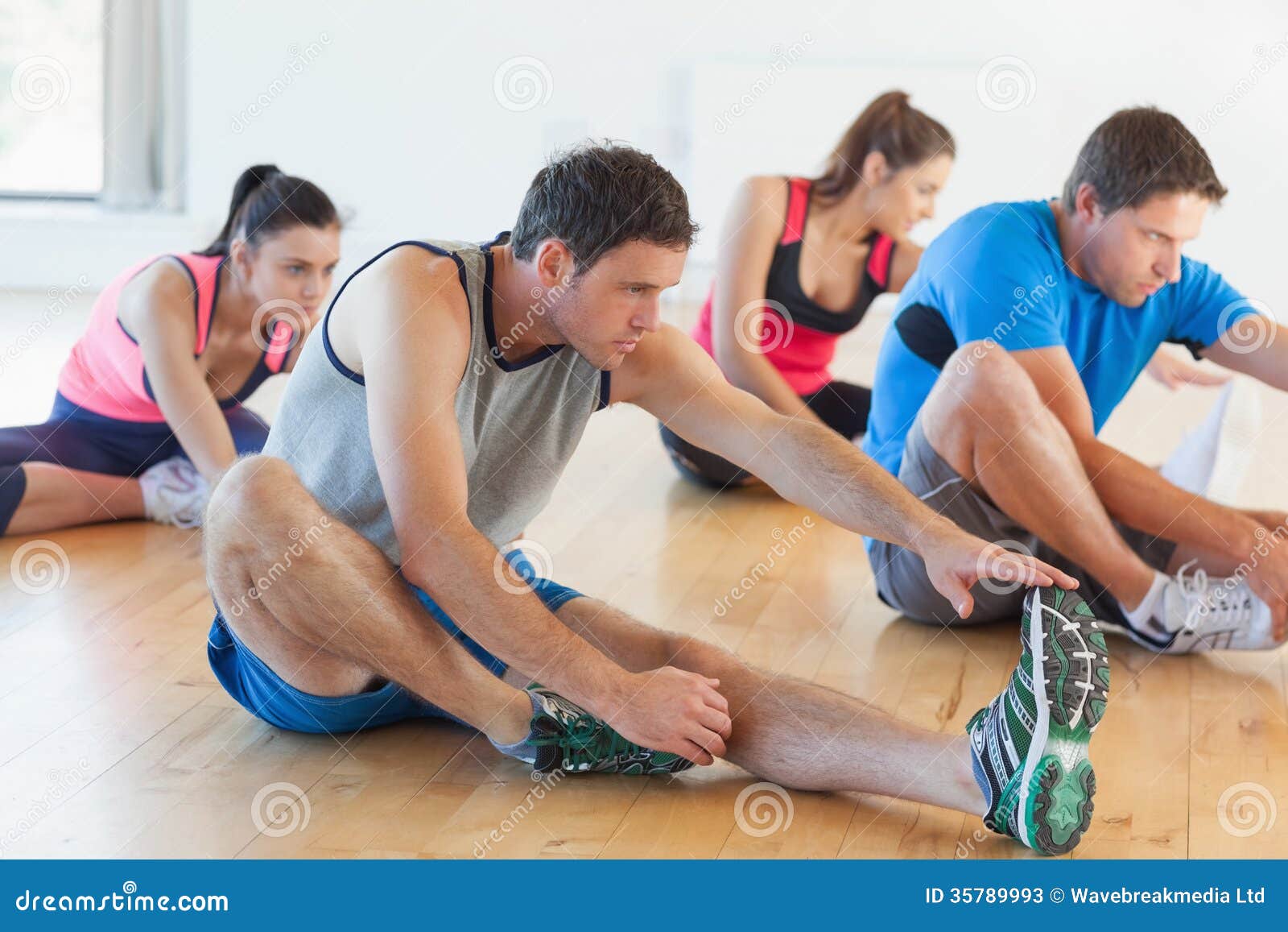 Class and Instructor Stretching Legs in Exercise Room Stock Image ...