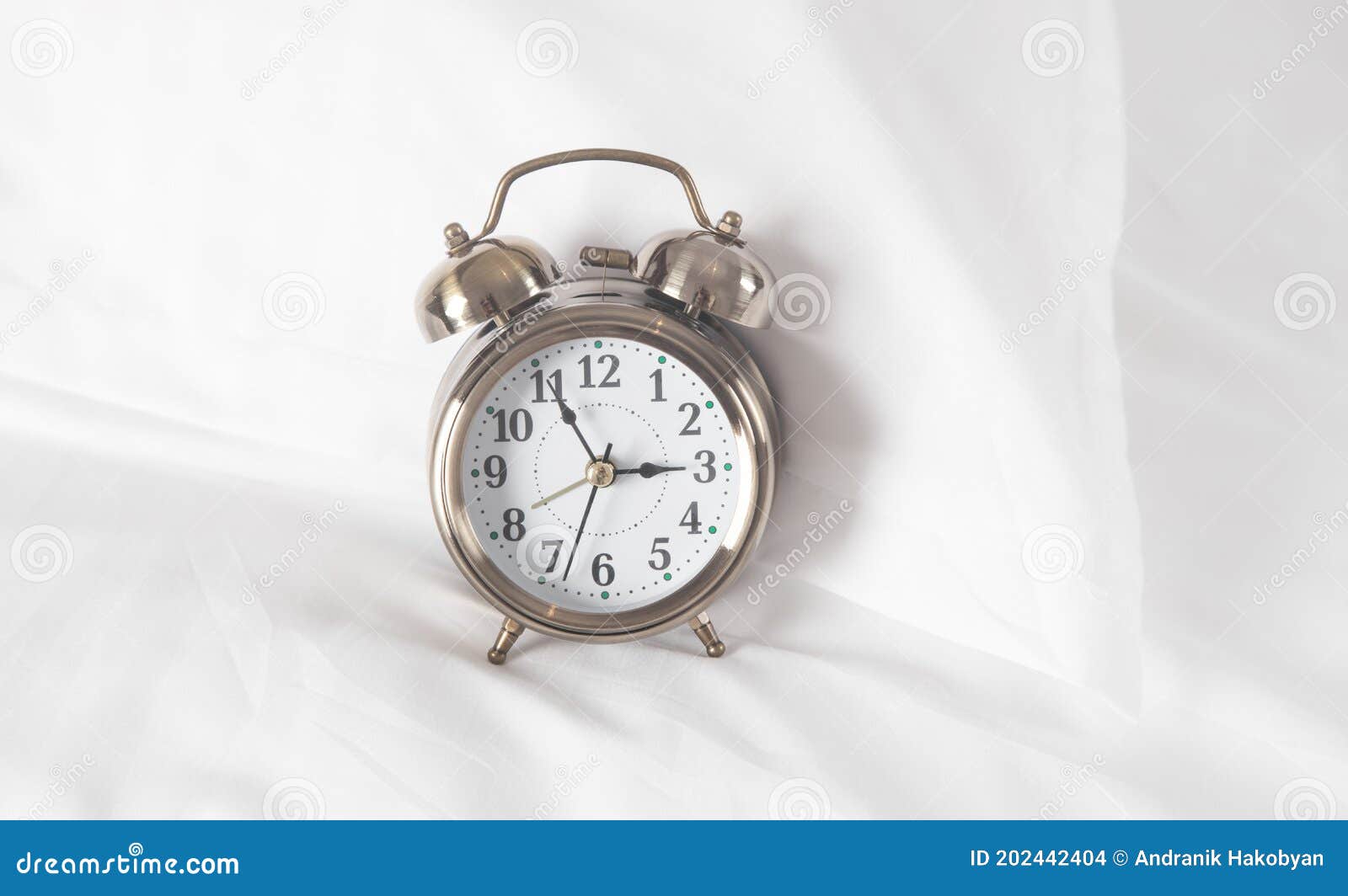Classic alarm clock on bed stock photo. Image of timer - 202442404