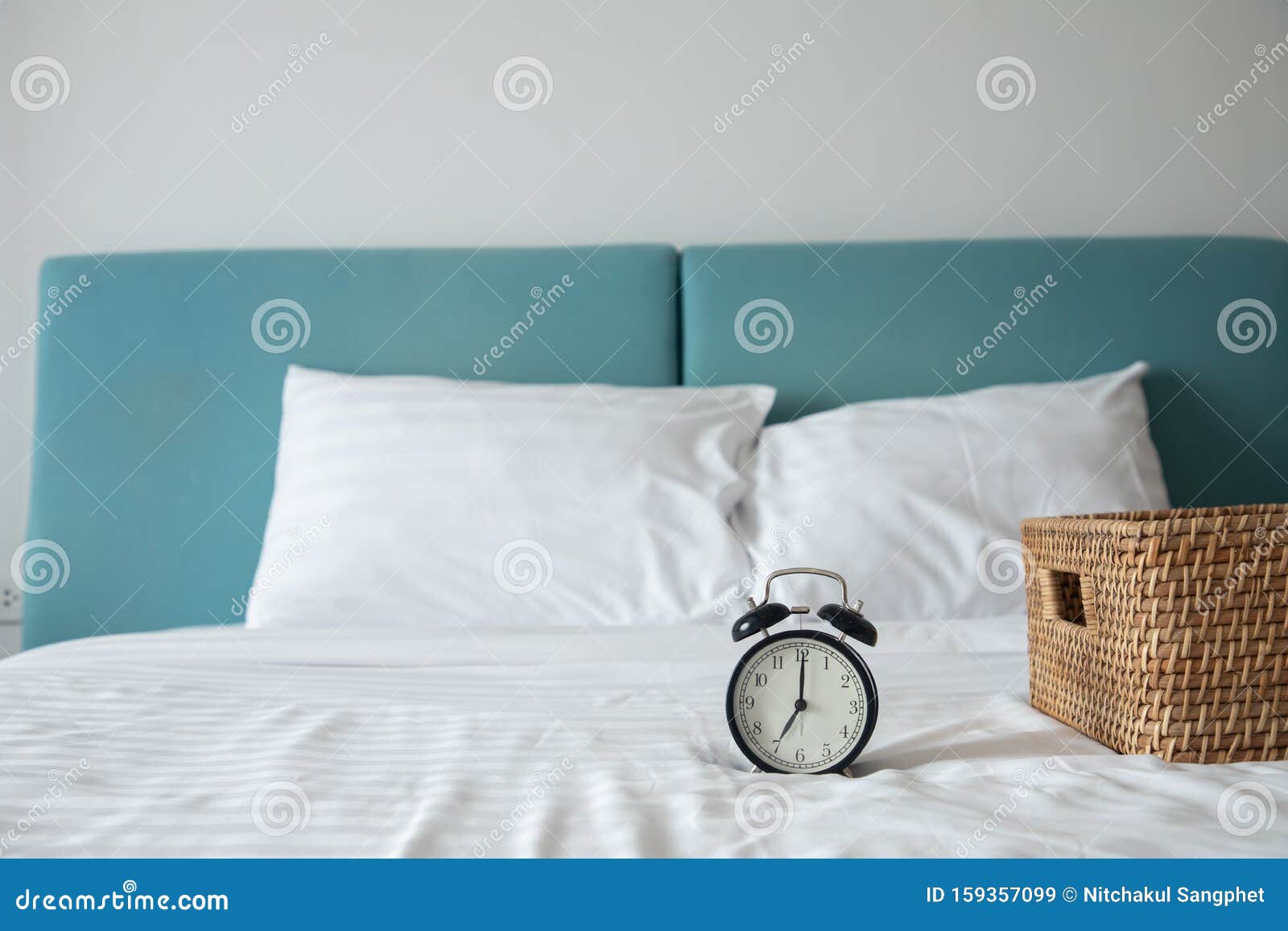 Classic Clock on White Bed with Wooden Basket on Bed in Bedroom Stock ...