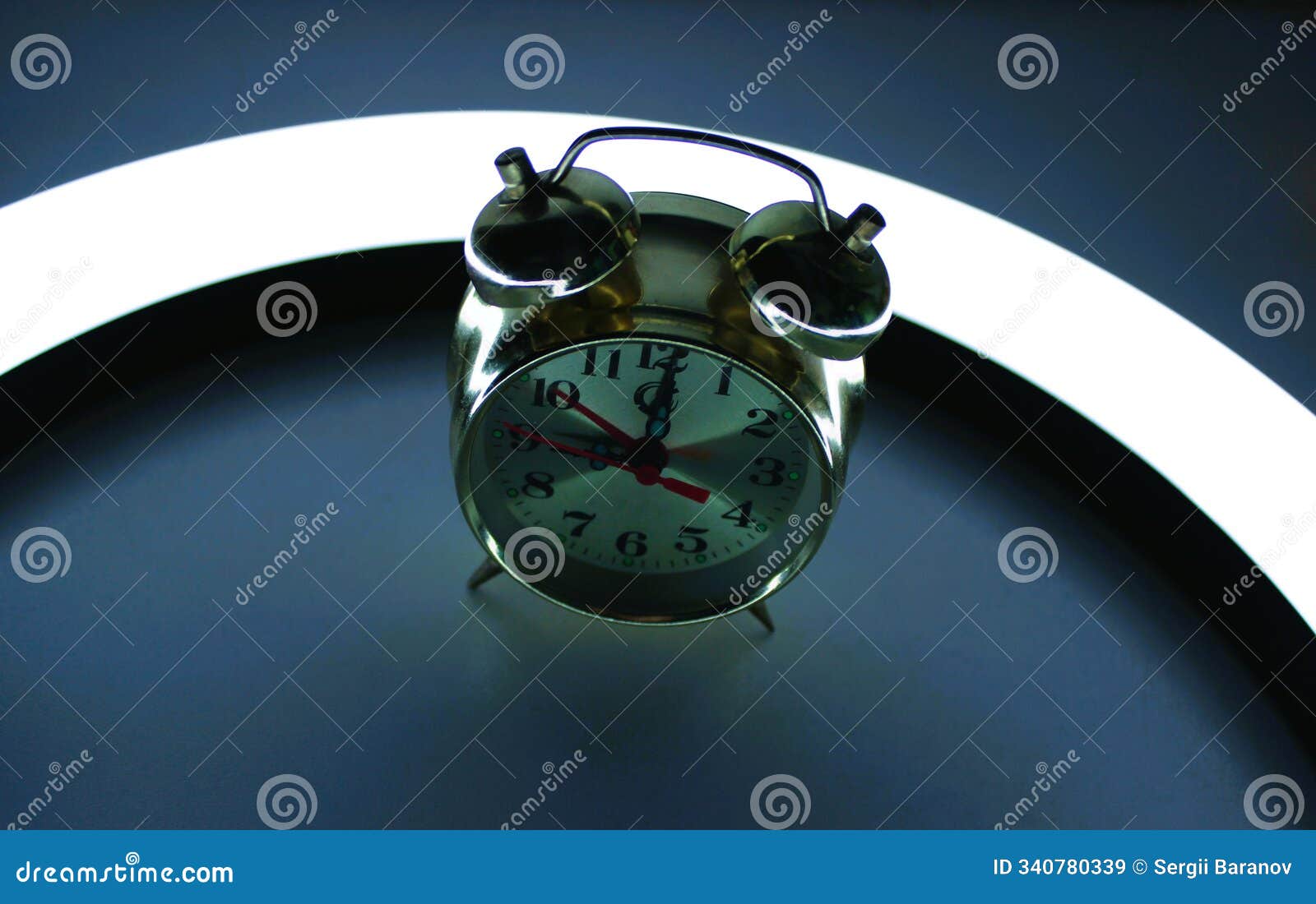 Classic Copper Clock with Bells on a Night Table with LED Ring Lamp in ...