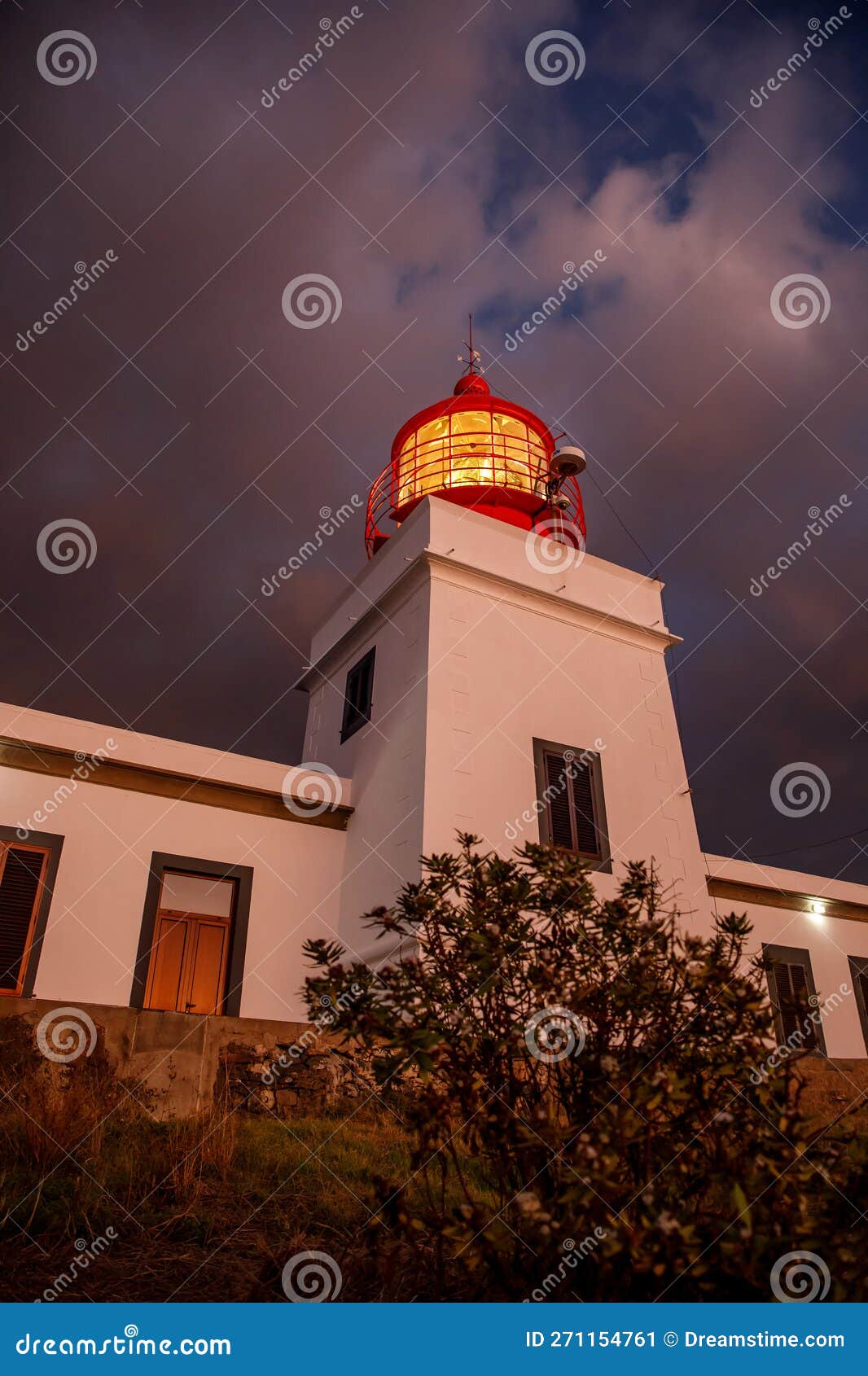 The Classic Illuminated Lighthouse with a Lamp on during the Sunset ...