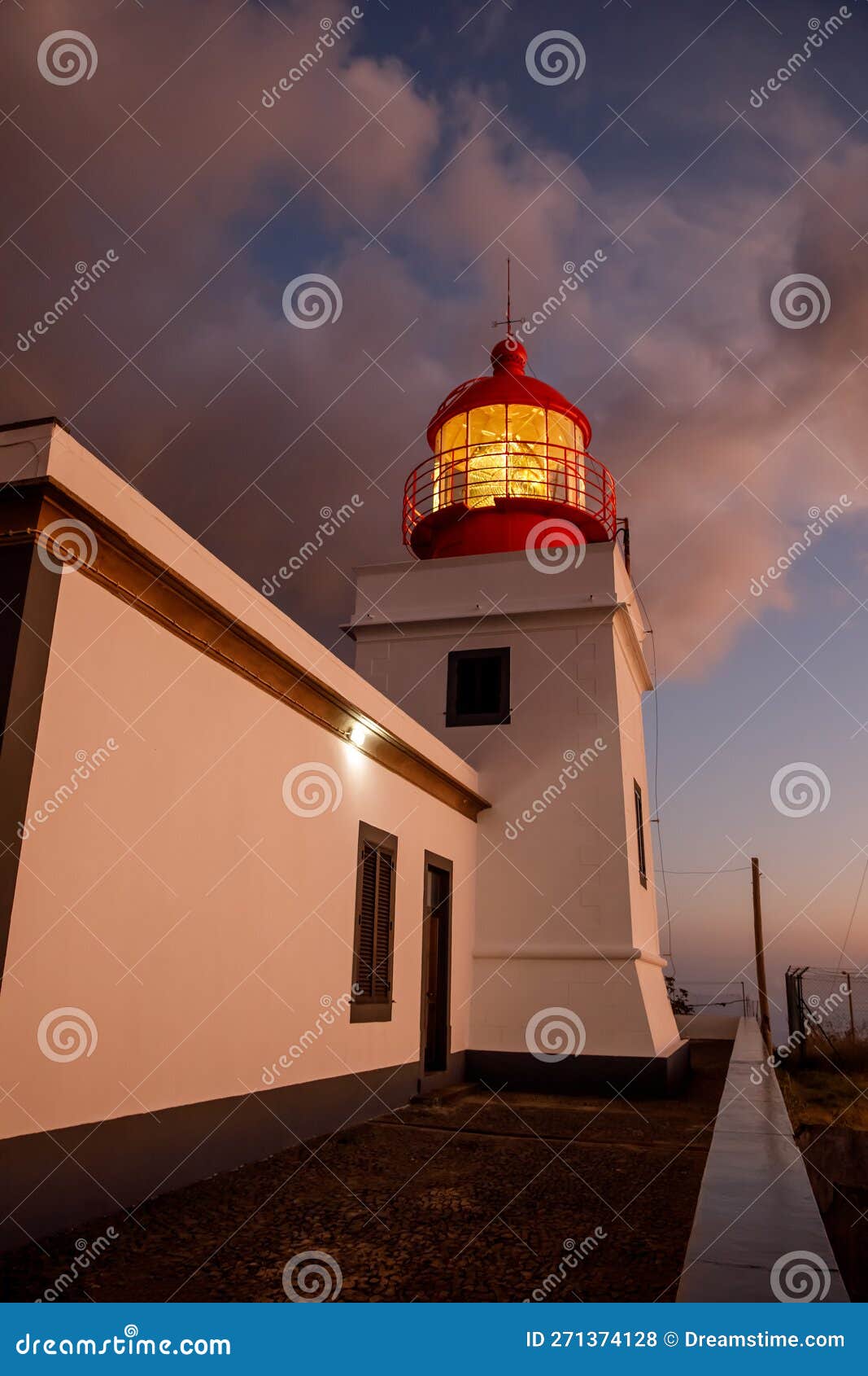 The Classic Illuminated Lighthouse with a Lamp on during the Sunset ...