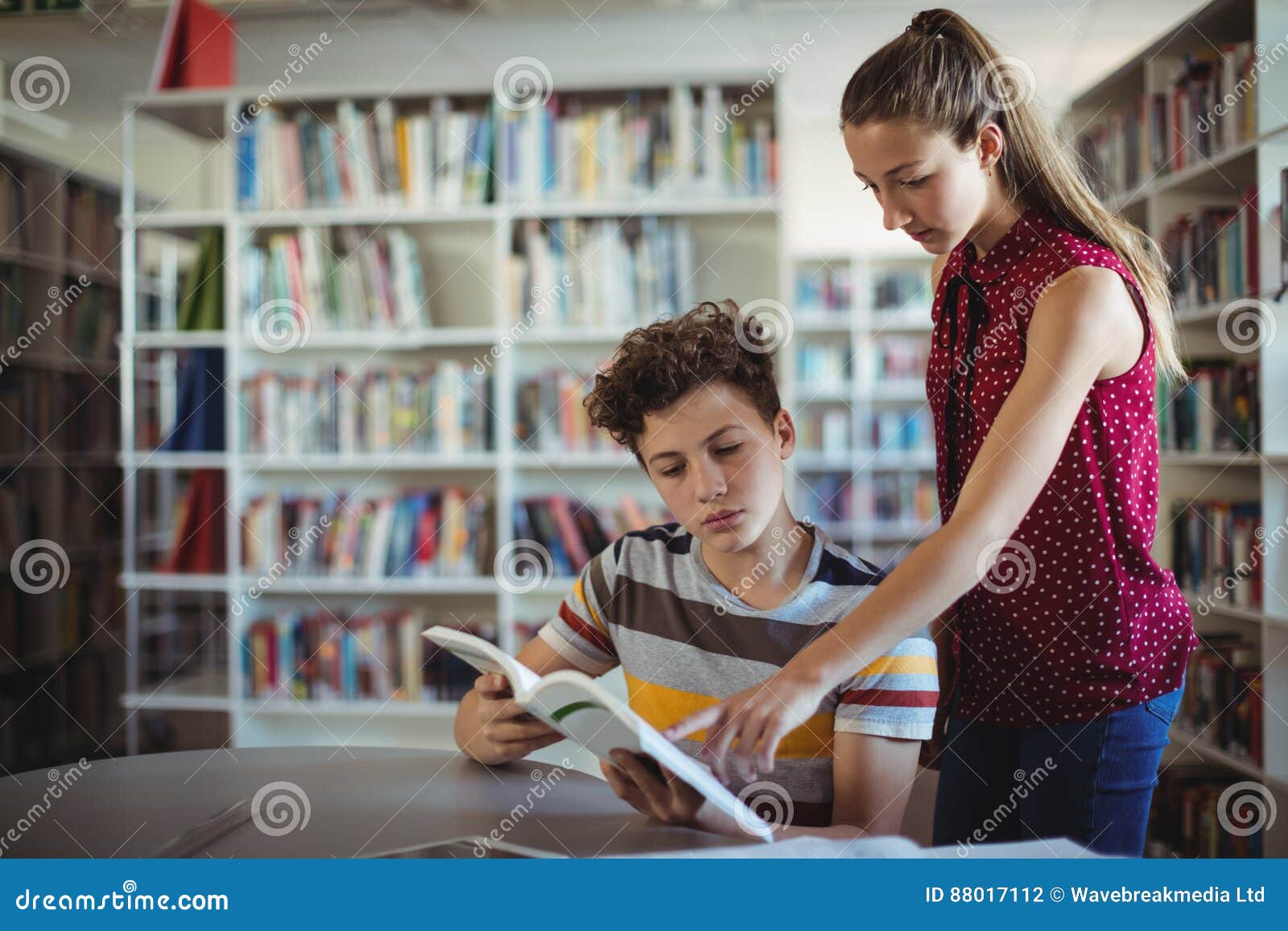 Classmates Reading Book in Library Stock Photo - Image of information ...