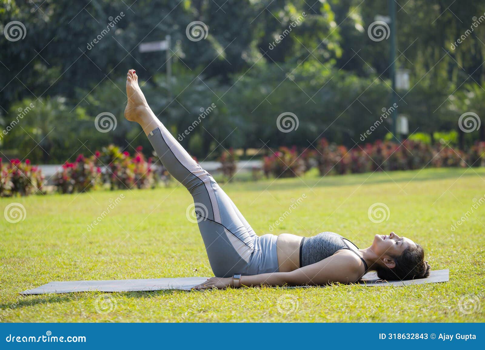 Classy Mature Woman Lying On The Park Raising Her Legs Up Stock Image