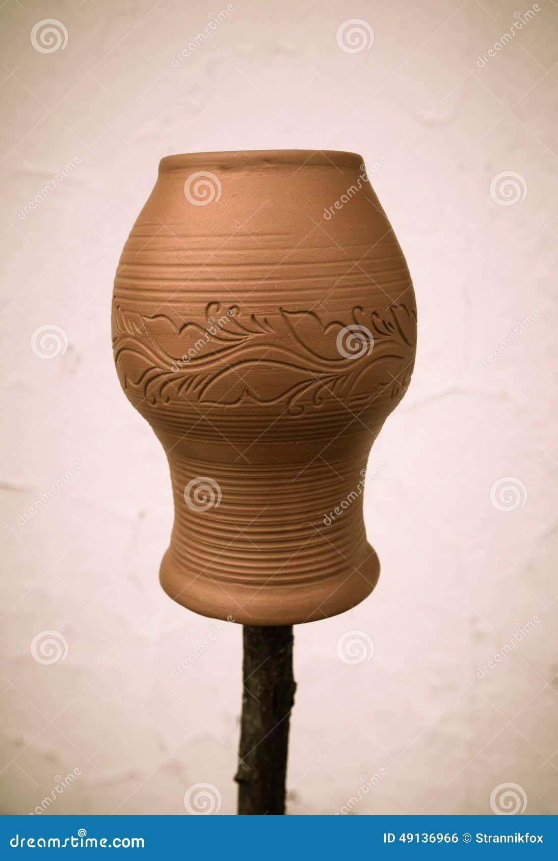 Clay Pot with a Pattern on a Wooden Stick on a Light Background. Stock ...