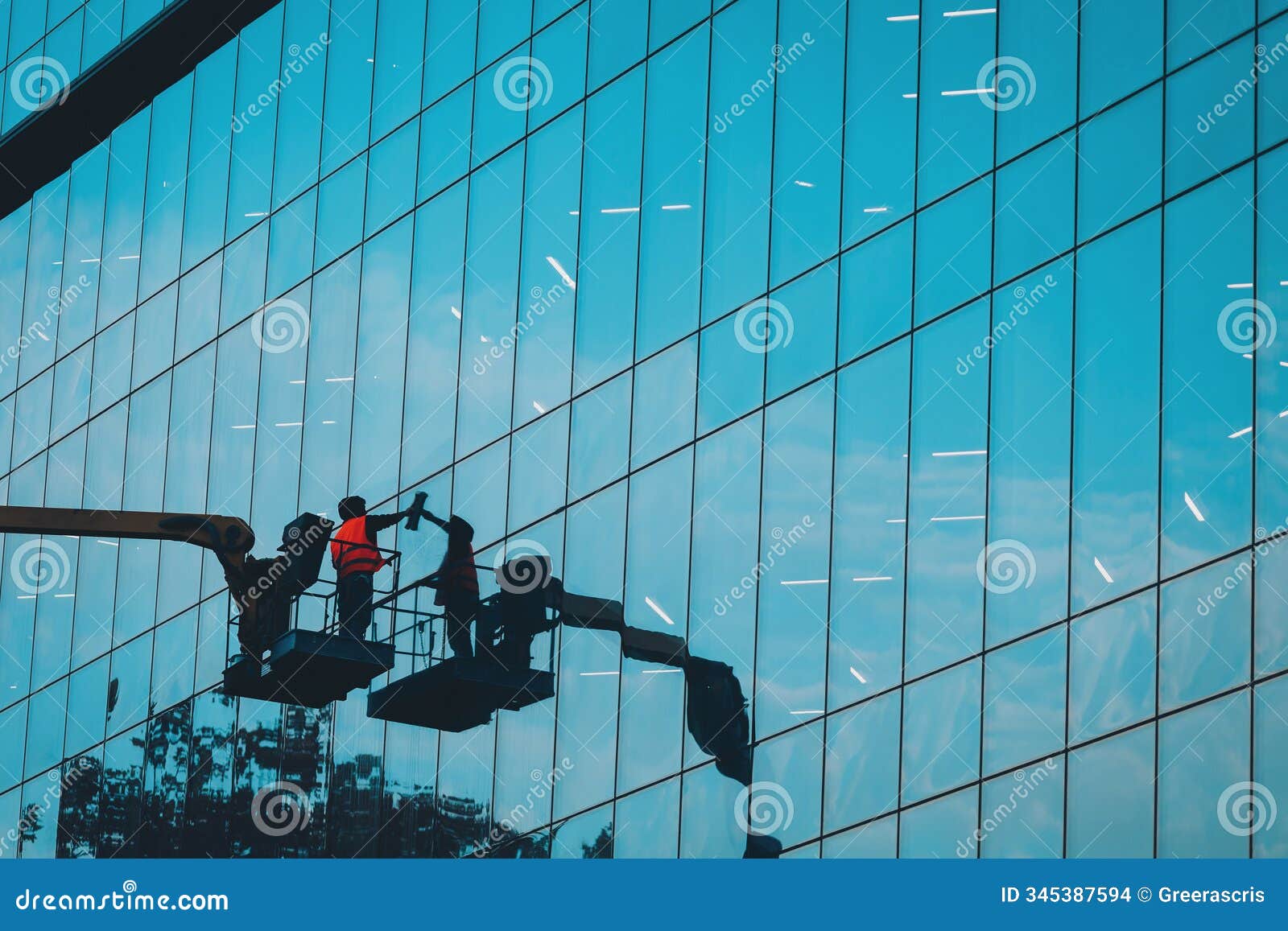 Cleaner Worker Using a Cherry Picker To Clean a Glass Facade of a ...