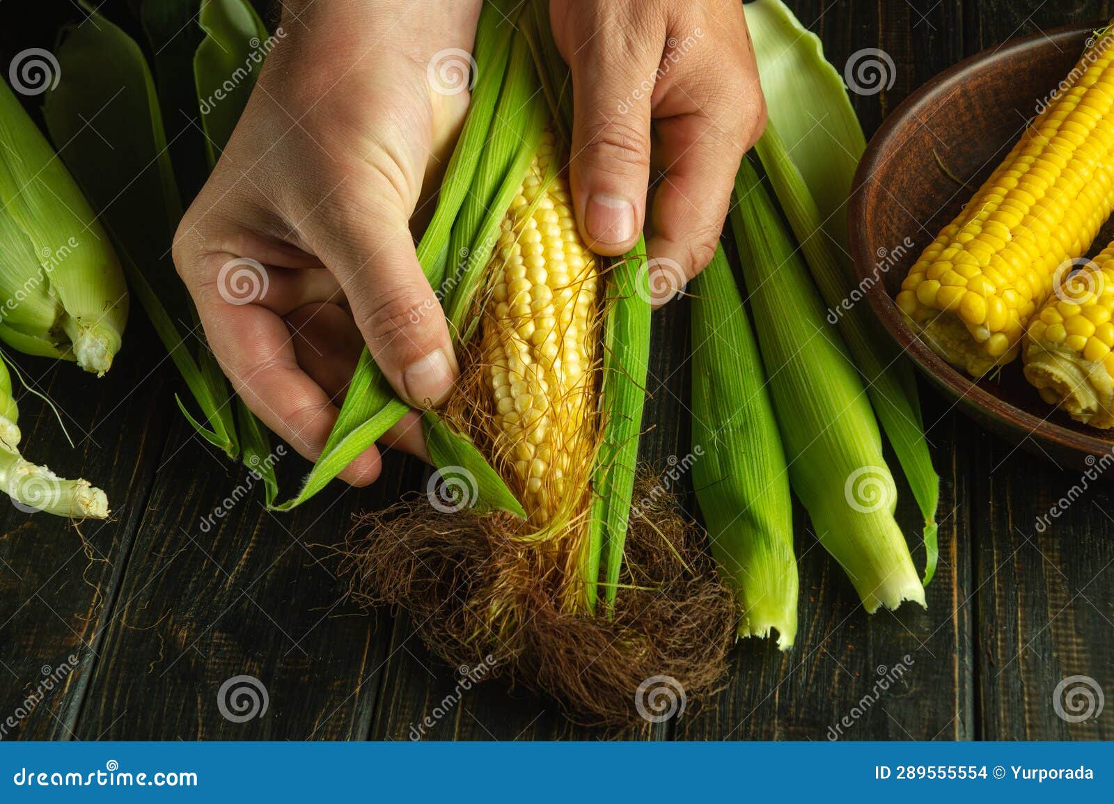 Cleaning Corn Heads from Green Husks. Cooking Corn on the Kitchen Table ...