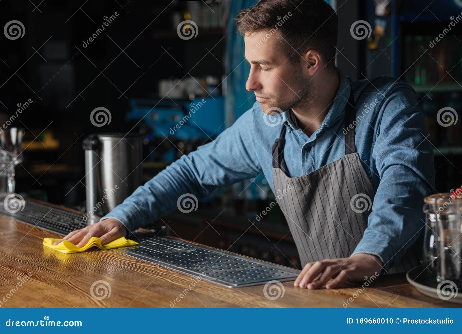 Cleanliness in Pub. Professional Bartender Standing at Counter, Wiping ...