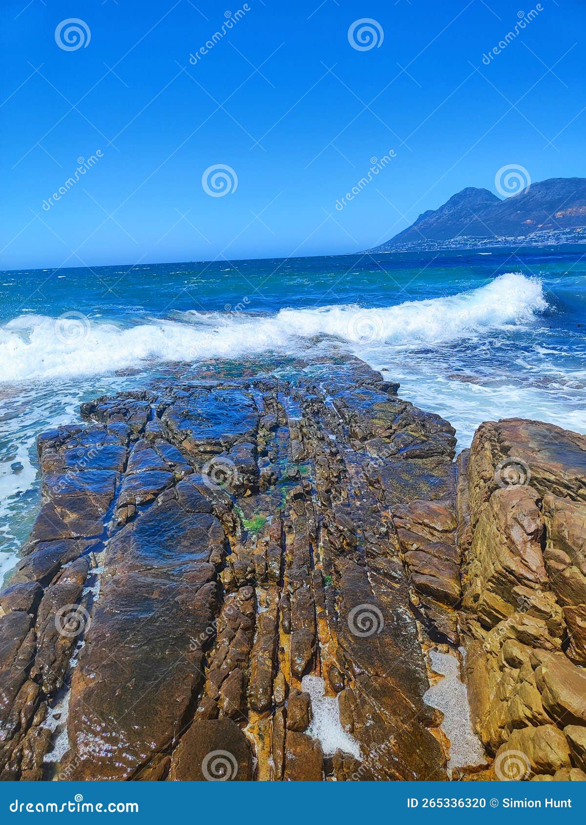 Clear Blue Sky with Waves Crashing on the Rocks Stock Photo - Image of ...