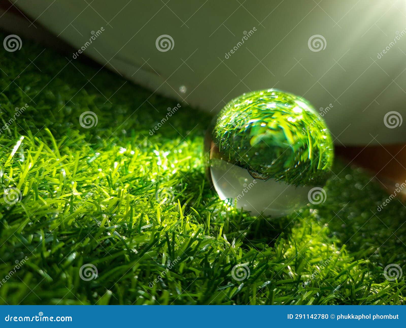 Clear Glass Ball on Plastic Grass, Sunlight Reflected. Stock Photo ...