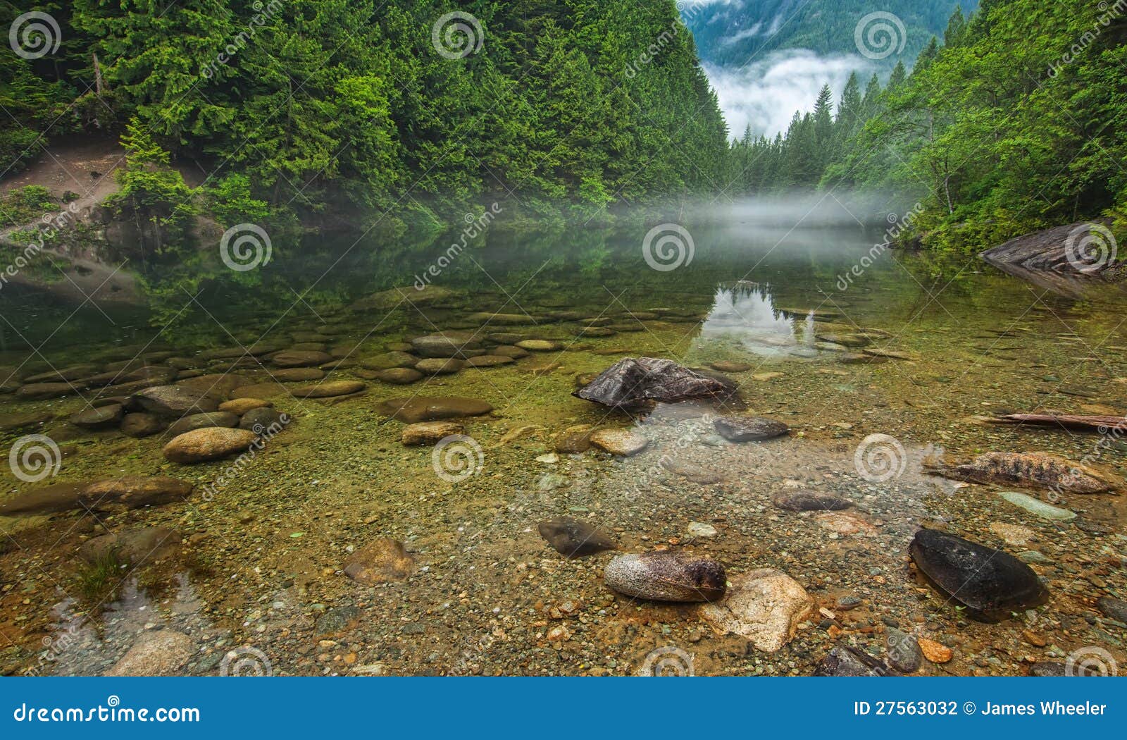Clear Lake with Rocks and Mist in Distance Stock Photo - Image of ...