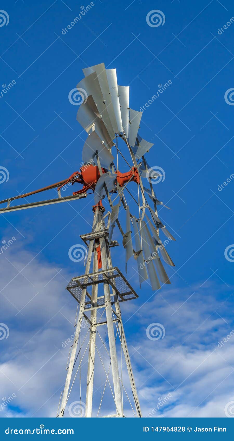 Clear Vertical Close Up of a Windpump with Vibrant Blue Sky and Puffy ...