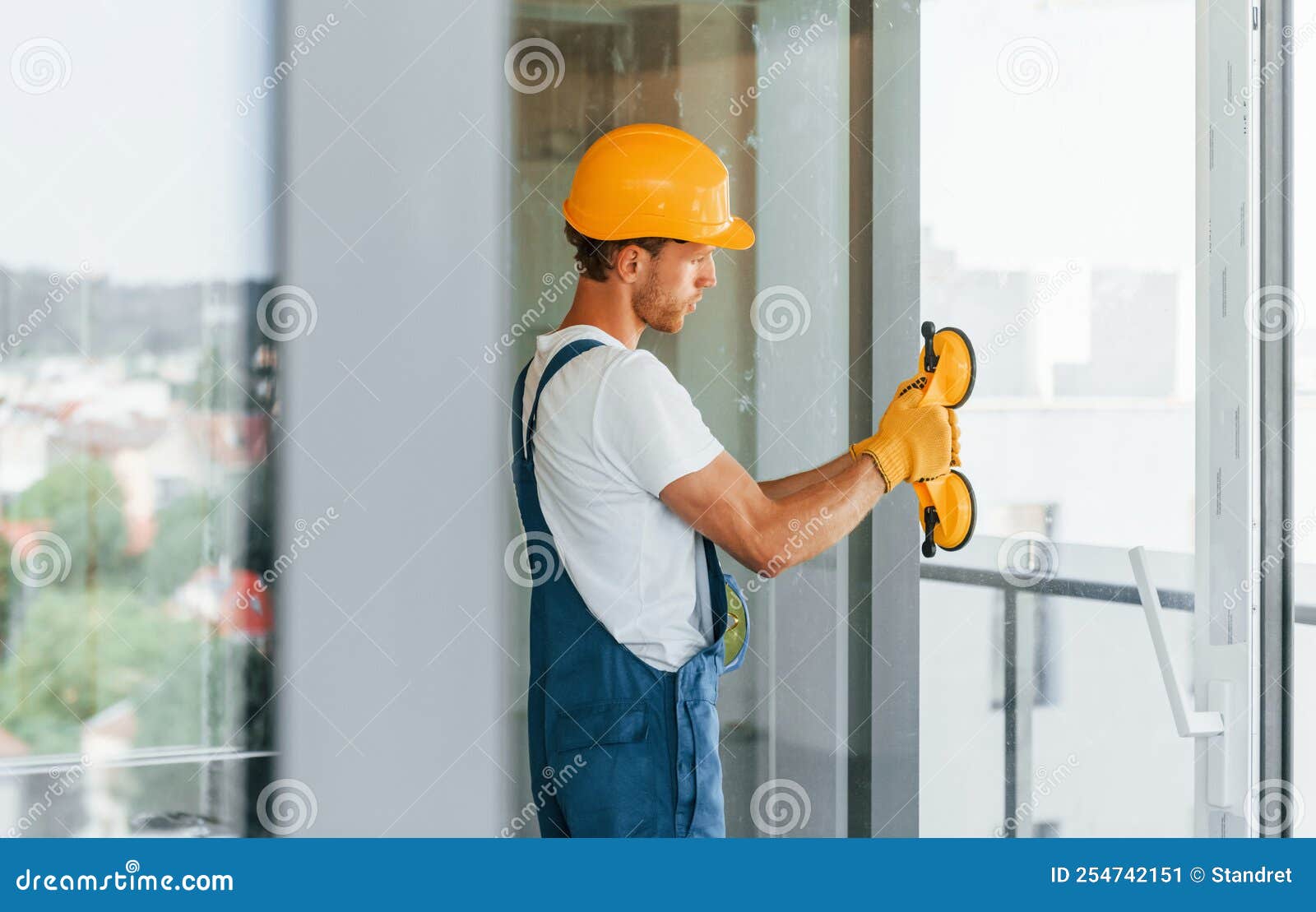 Clearing Windows. Young Man Working in Uniform at Construction at ...