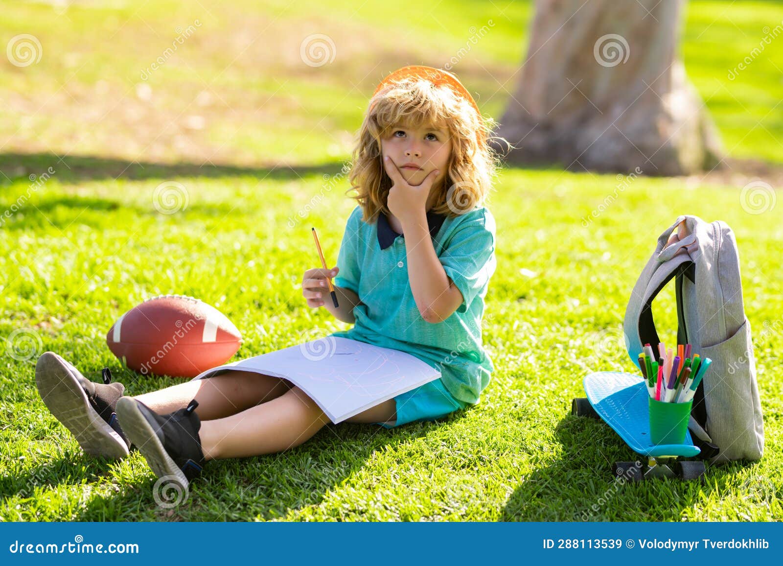 Clever School Boy Doing Homework, Writing on Copy Book in Green Grass ...