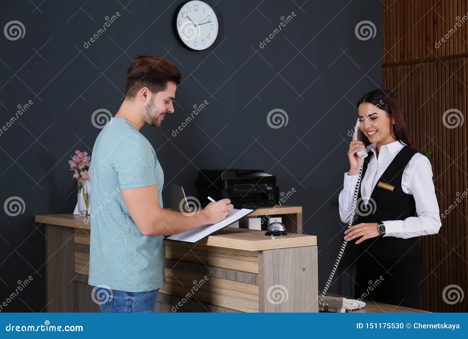 Client Registering at Desk while Receptionist Talking on Phone Stock ...