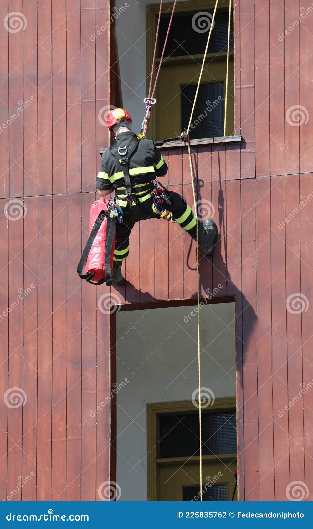 A Man Firefighter Enters The Entrance Of A Multi-storey Building To ...
