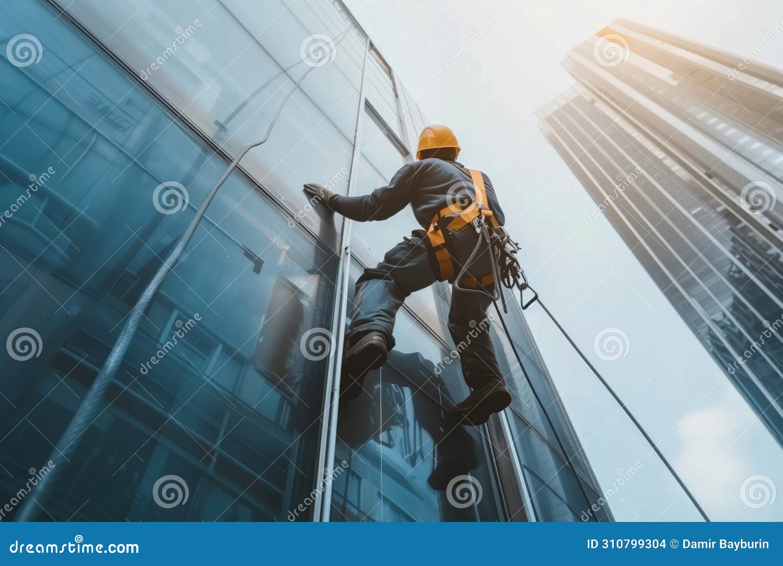 A Man is Climbing Up the Side of a Tall Building Stock Photo - Image of ...