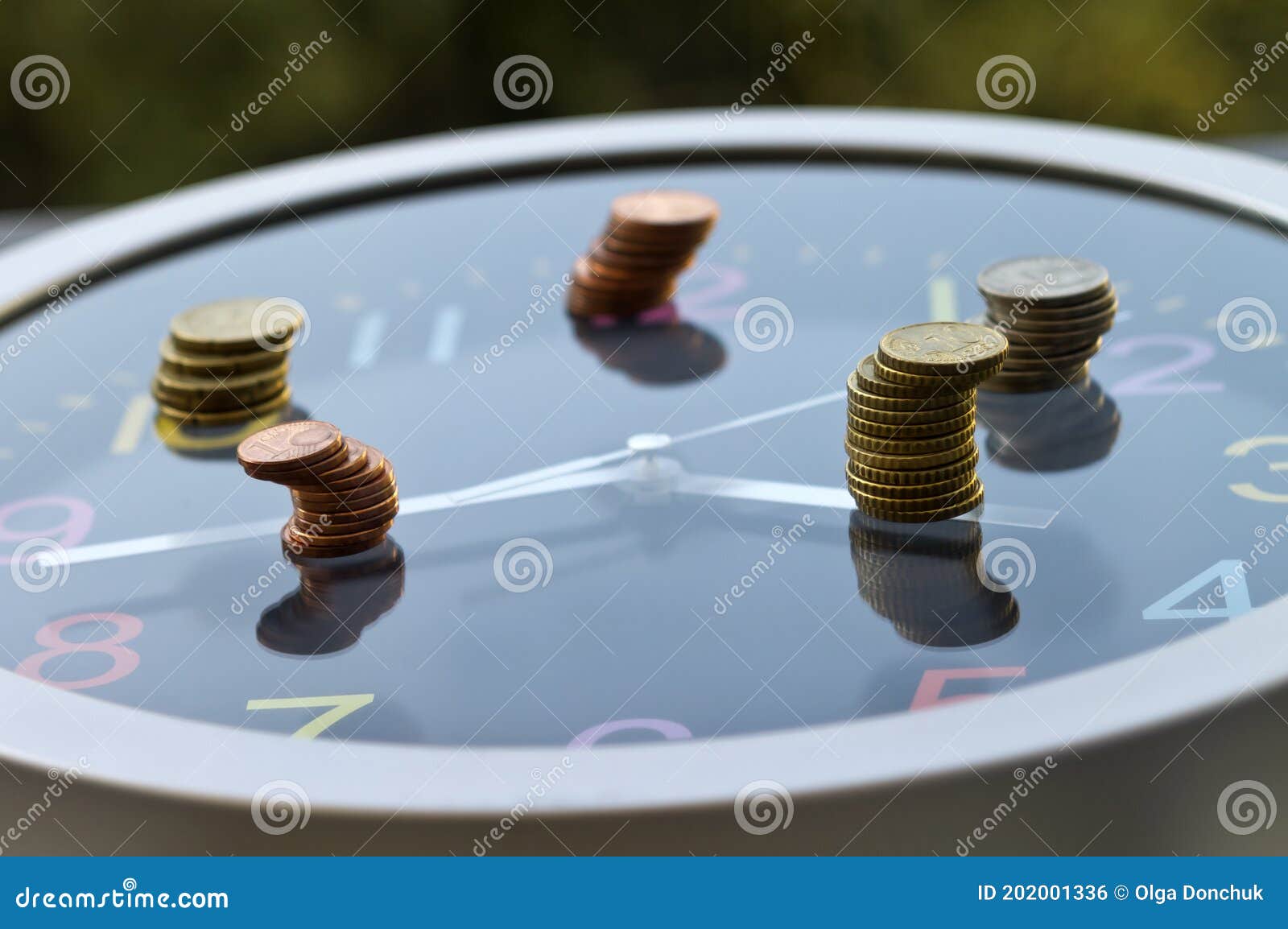 Clock face with coin piles stock photo. Image of investment - 202001336