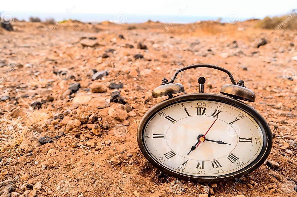 A Clock is Laying on the Ground in a Desert Stock Photo - Image of ...
