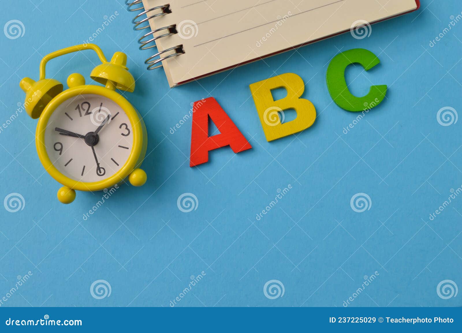 Clock, Notebook and ABC Letters Isolated on a Blue Background with Copy ...