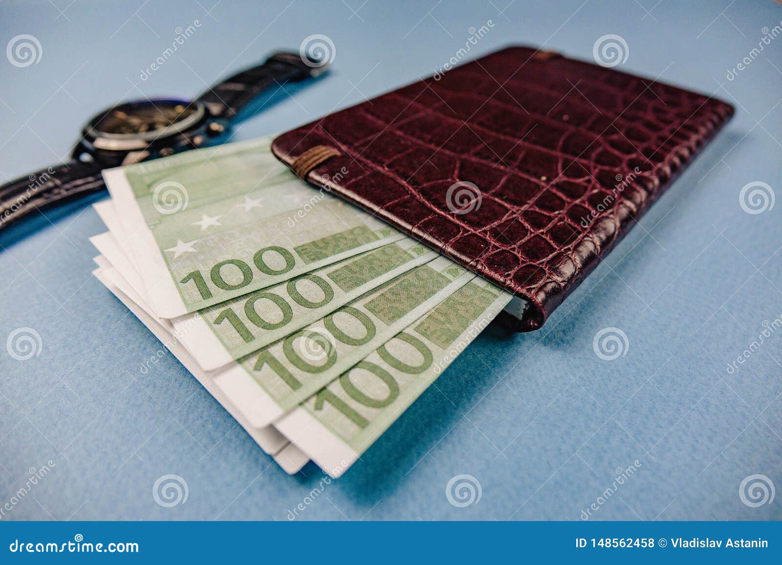 Clock and Wallet with Money Lying on a Blue Background Stock Photo ...