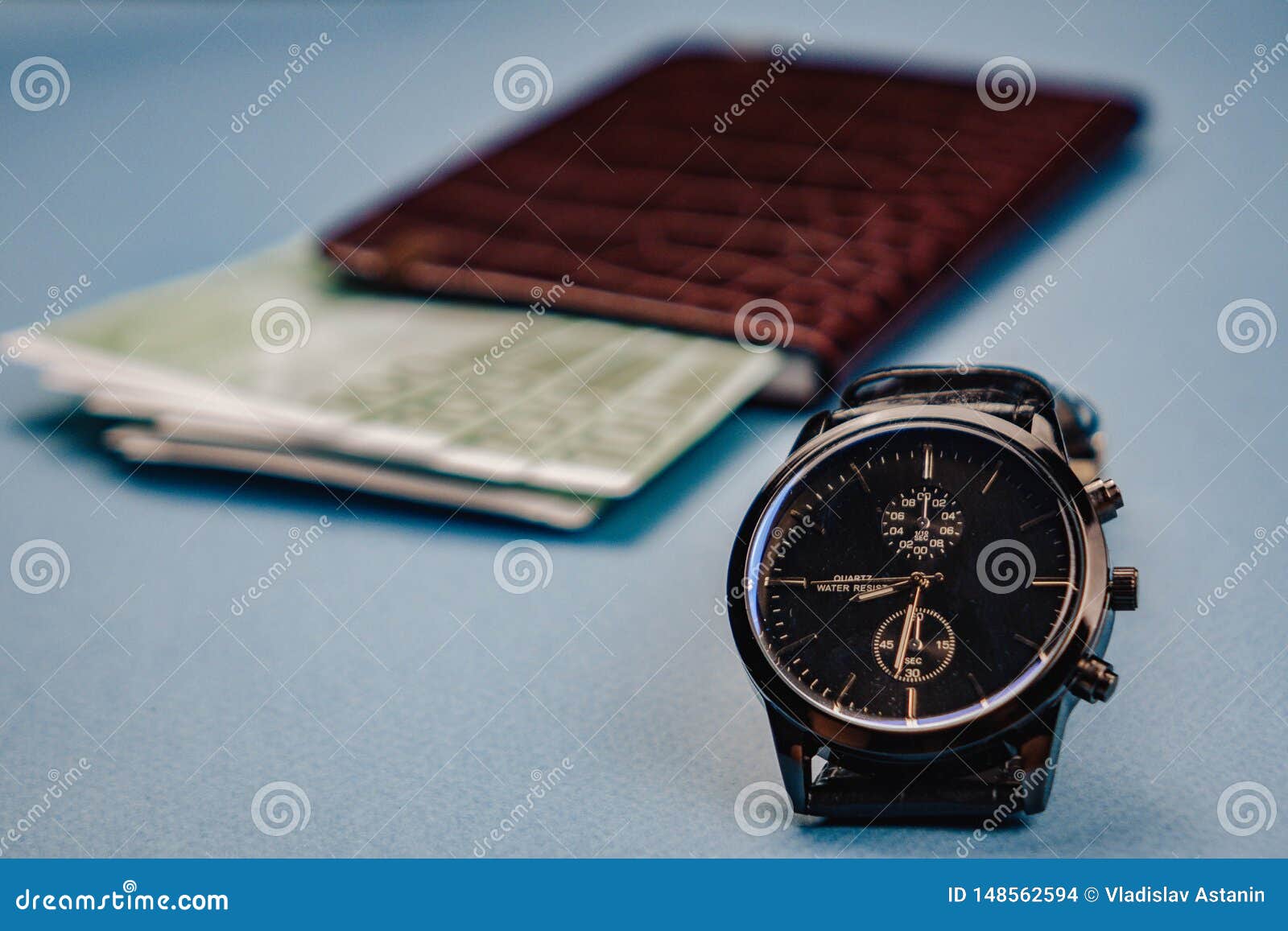 Clock and Wallet with Money Lying on a Blue Background Stock Photo ...