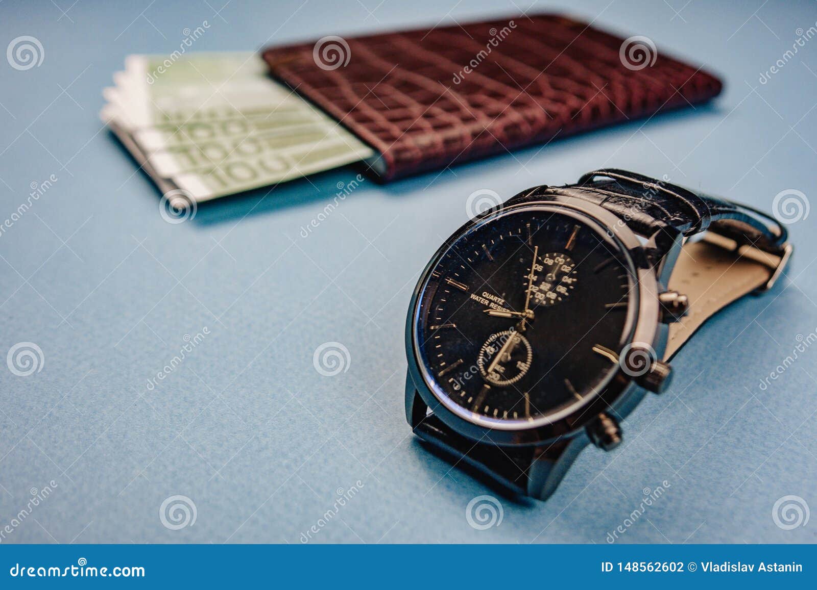 Clock and Wallet with Money Lying on a Blue Background Stock Photo ...