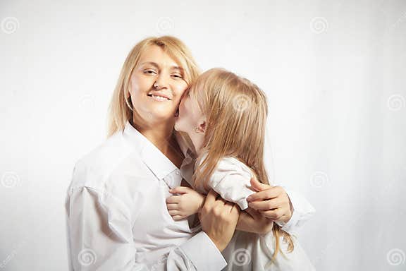 Close Portrait Of A Blonde Mother And Daughter With Hugs On A White