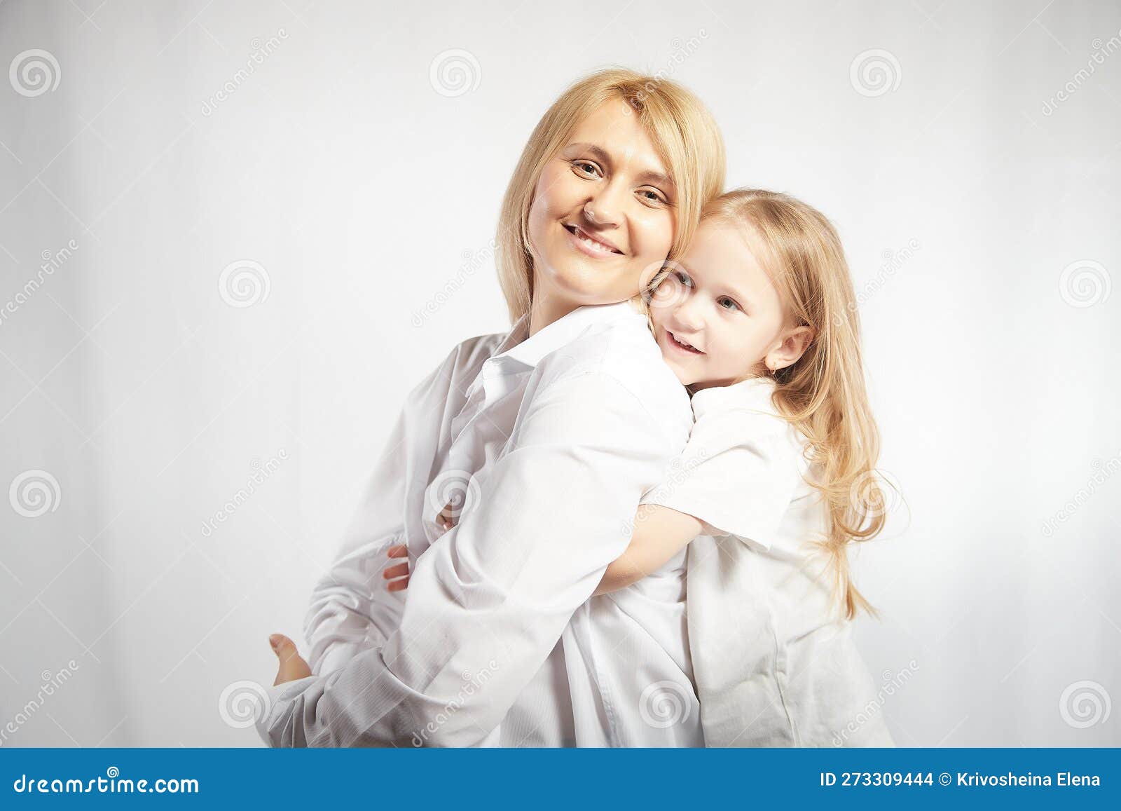 Close Portrait Of A Blonde Mother And Daughter With Hugs On A White