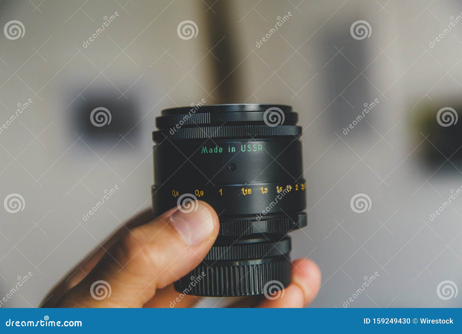 Close Shot Of A Person Holding A Camera Lens With A Blurred Background ...