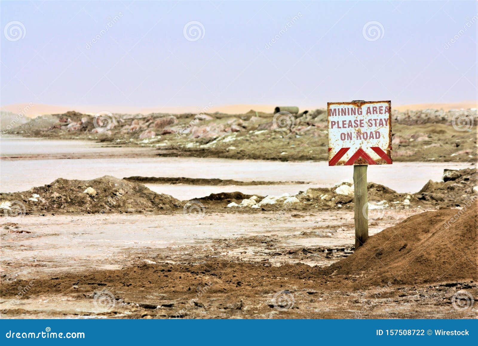 Close Shot of a Warning Sign in a Muddy Ground with a Clear Sky in the ...