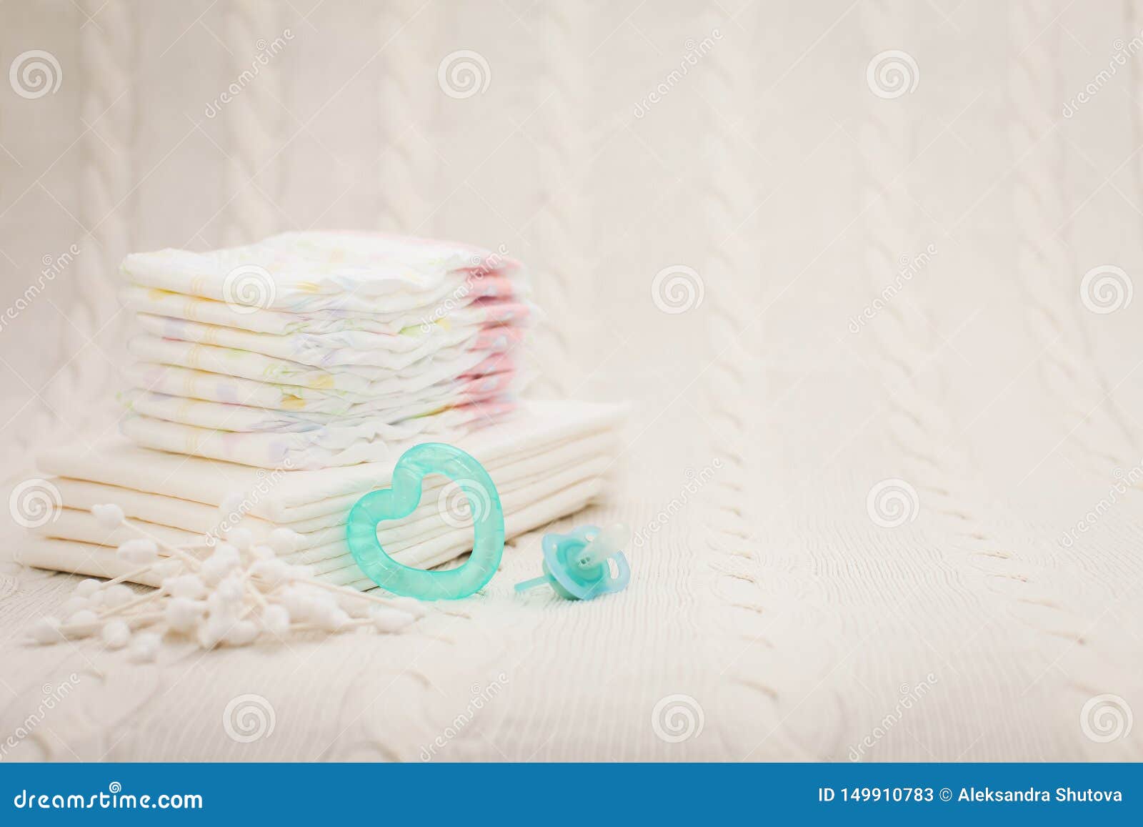 Close Up Baby Hygiene Items. Stack of Diapers, Ear Sticks, Baby Dummy ...
