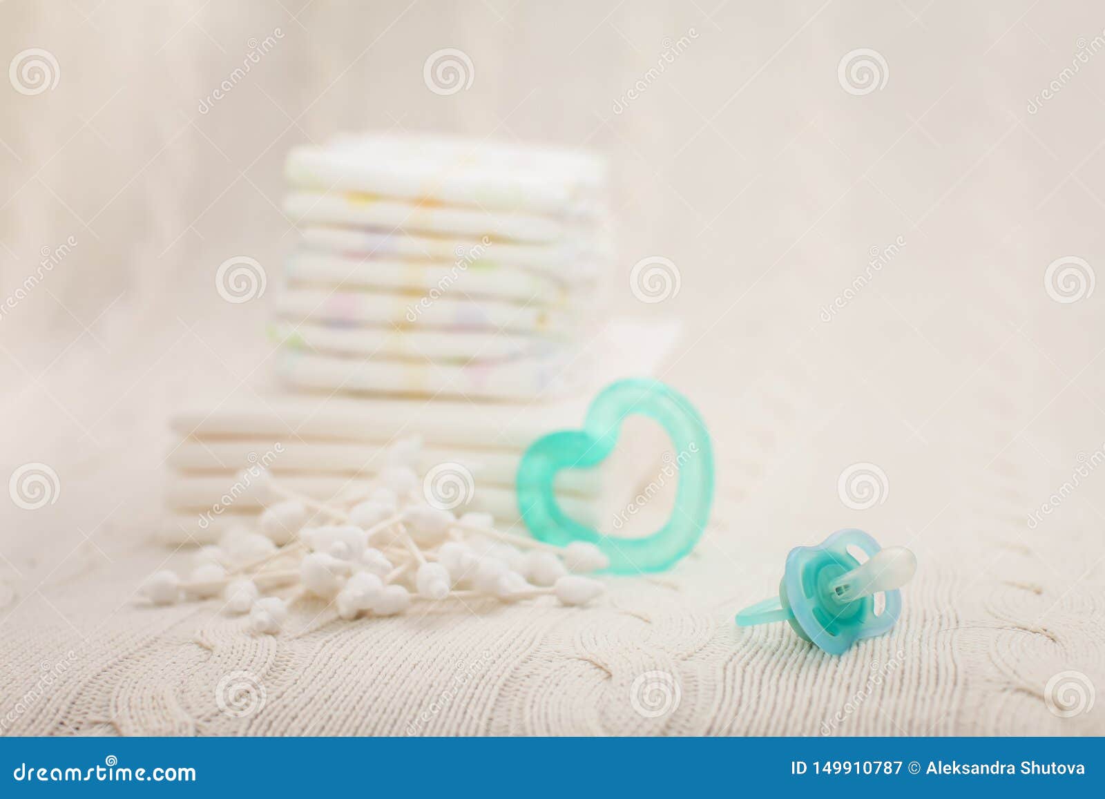 Close Up Baby Hygiene Items. Stack of Diapers, Ear Sticks, Baby Dummy ...