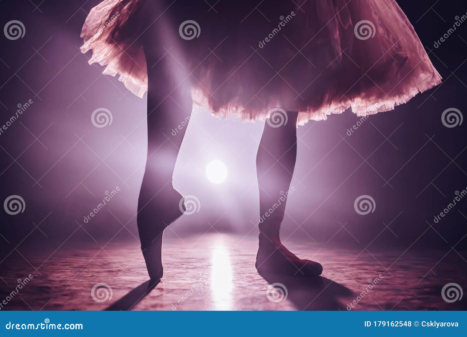 Close Up Of Ballet Dancer As She Practices Exercises On Dark Stage Or